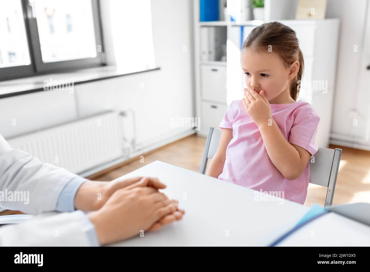 doctor and little girl patient coughing at clinic Stock Photo - Alamy