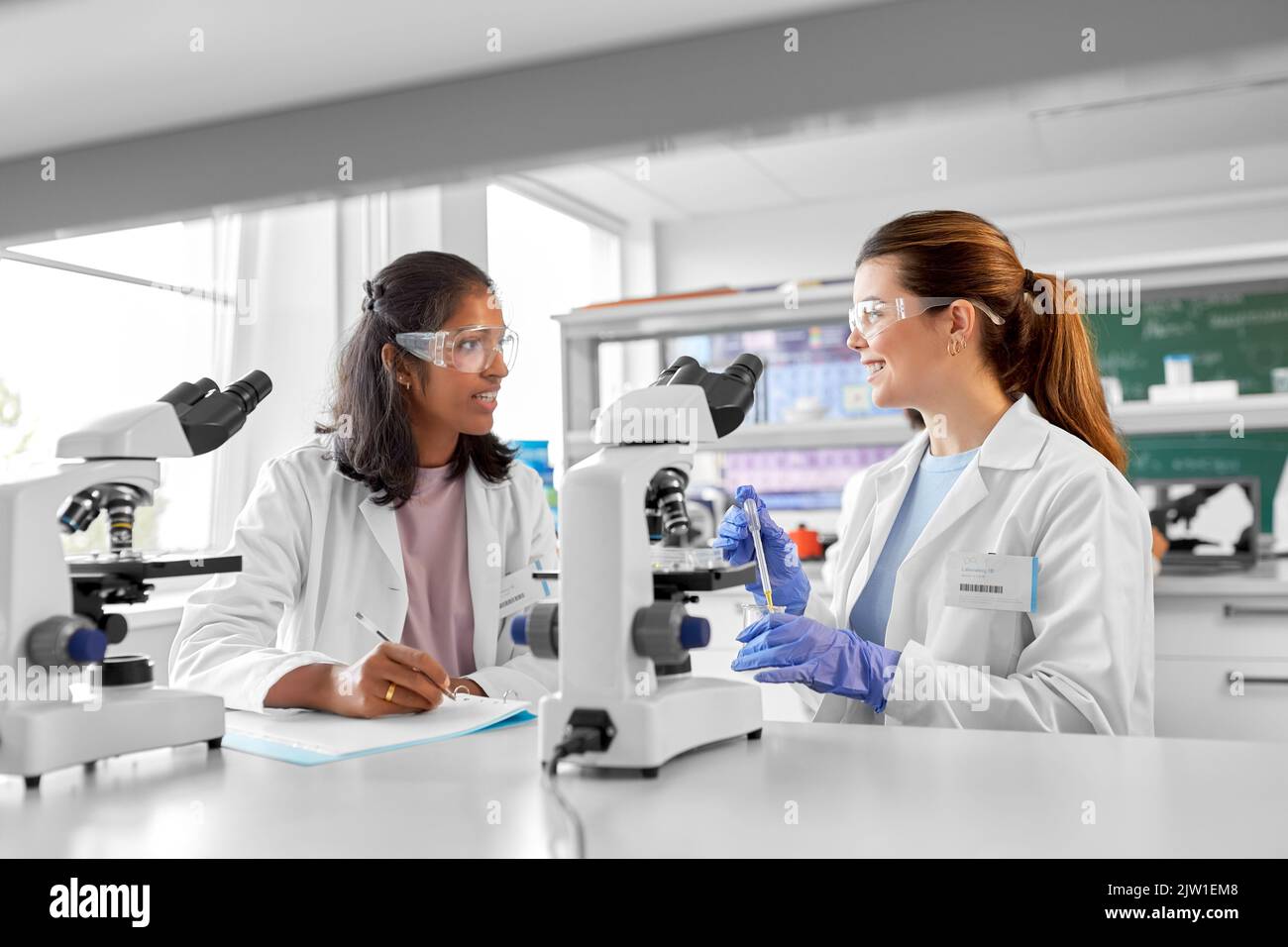 scientists with microscopes working in laboratory Stock Photo - Alamy