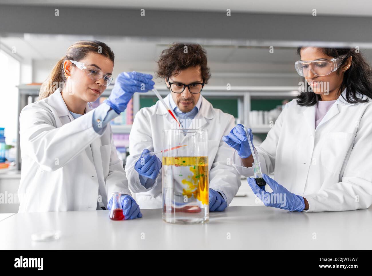 scientists with chemicals working in laboratory Stock Photo - Alamy