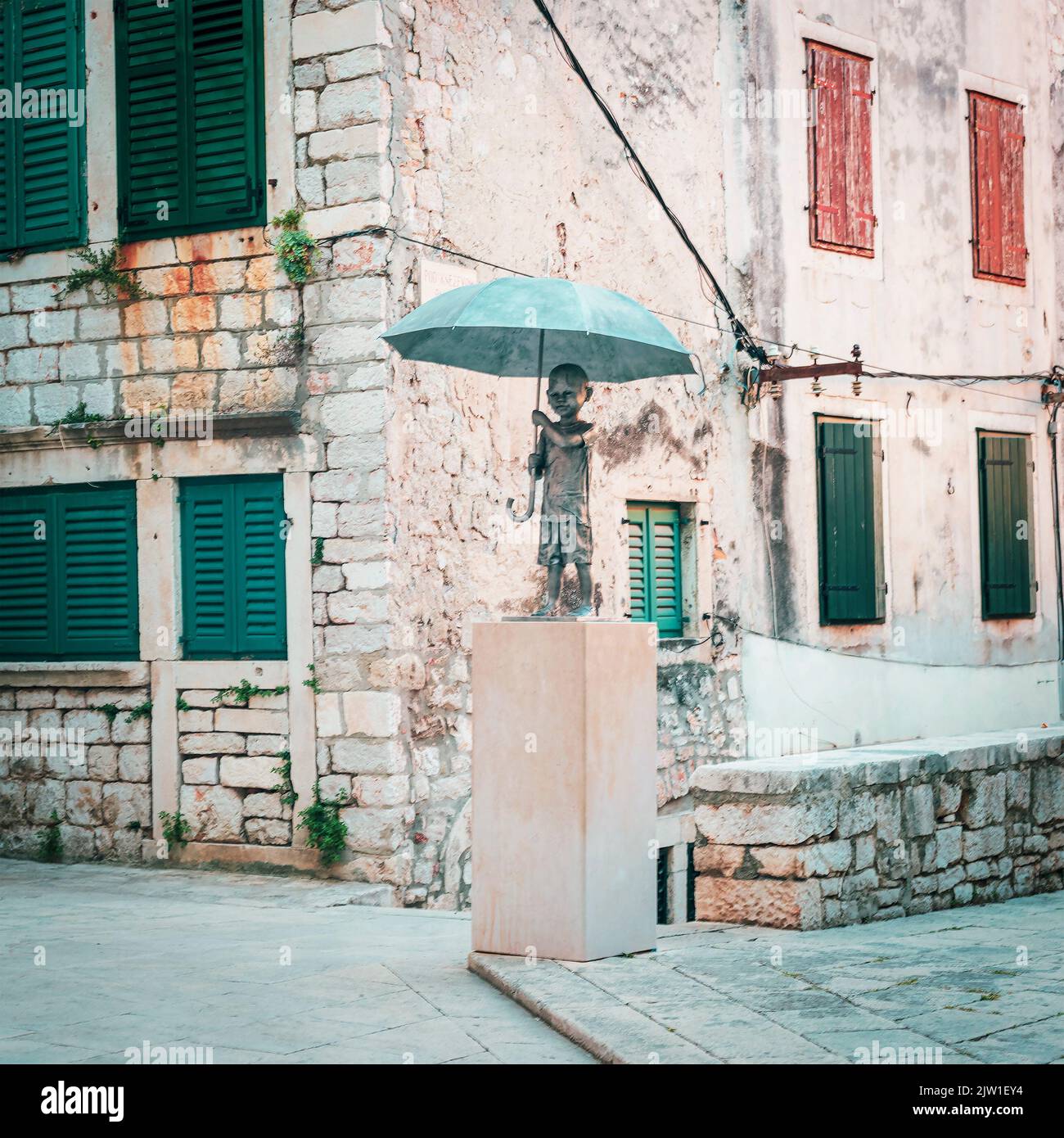 Statue of a boy holding the umbrella, tourist attraction in Sibenik ...