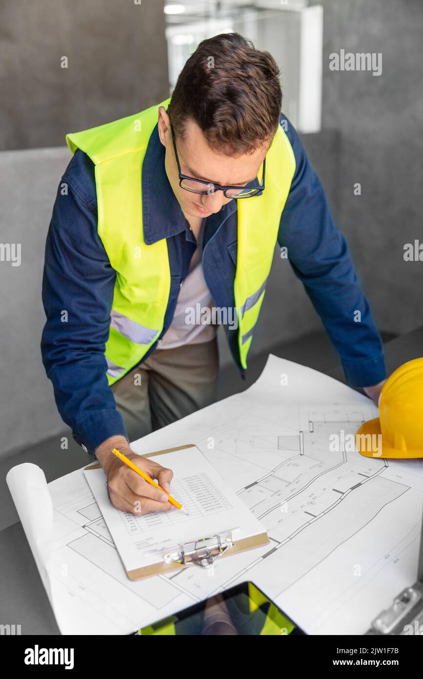 architect with blueprint and clipboard at office Stock Photo - Alamy