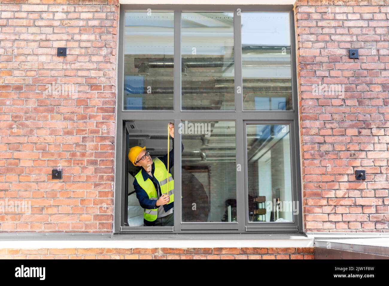 male builder with ruler measuring window Stock Photo - Alamy