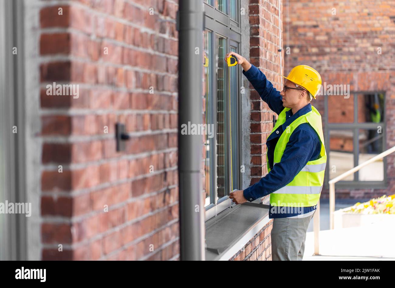 male builder with ruler measuring window Stock Photo - Alamy