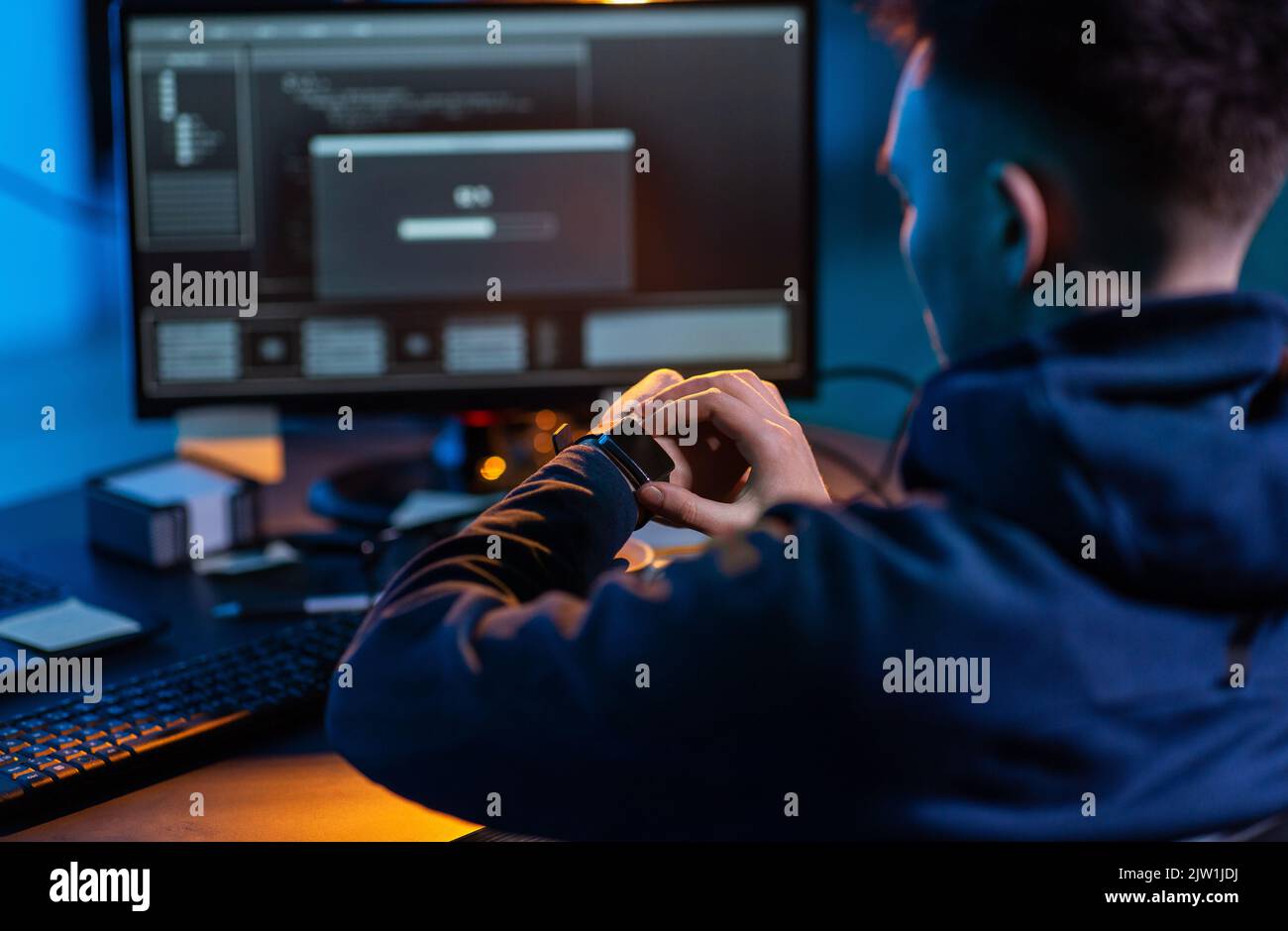 hacker with smart watch and computers in dark room Stock Photo - Alamy
