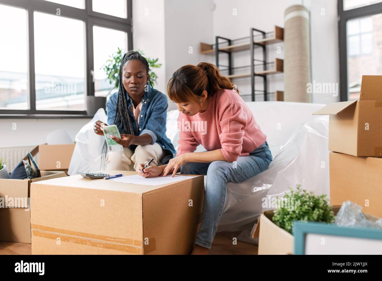 women moving to new home and counting money Stock Photo - Alamy