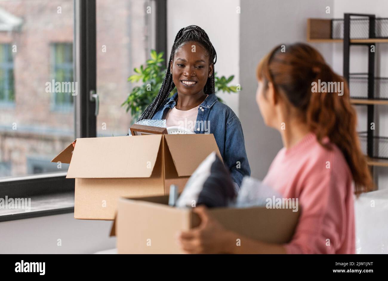 women with boxes moving to new home Stock Photo - Alamy