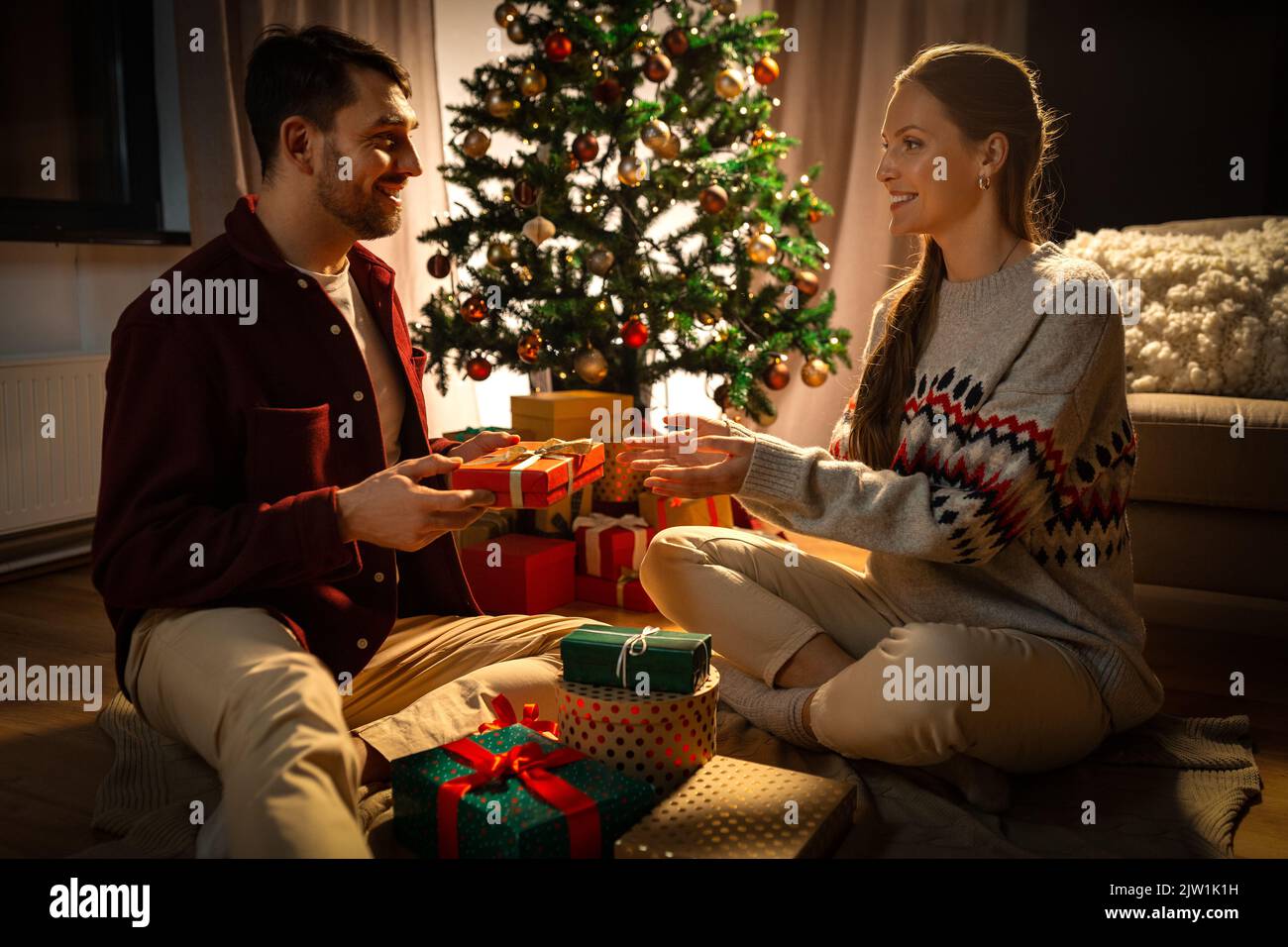 happy couple with christmas gift at home Stock Photo - Alamy