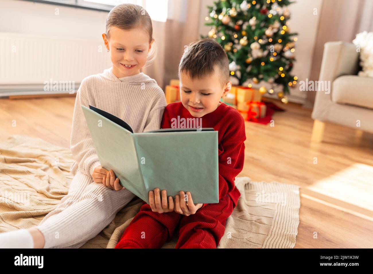 happy children reading book on christmas at home Stock Photo - Alamy