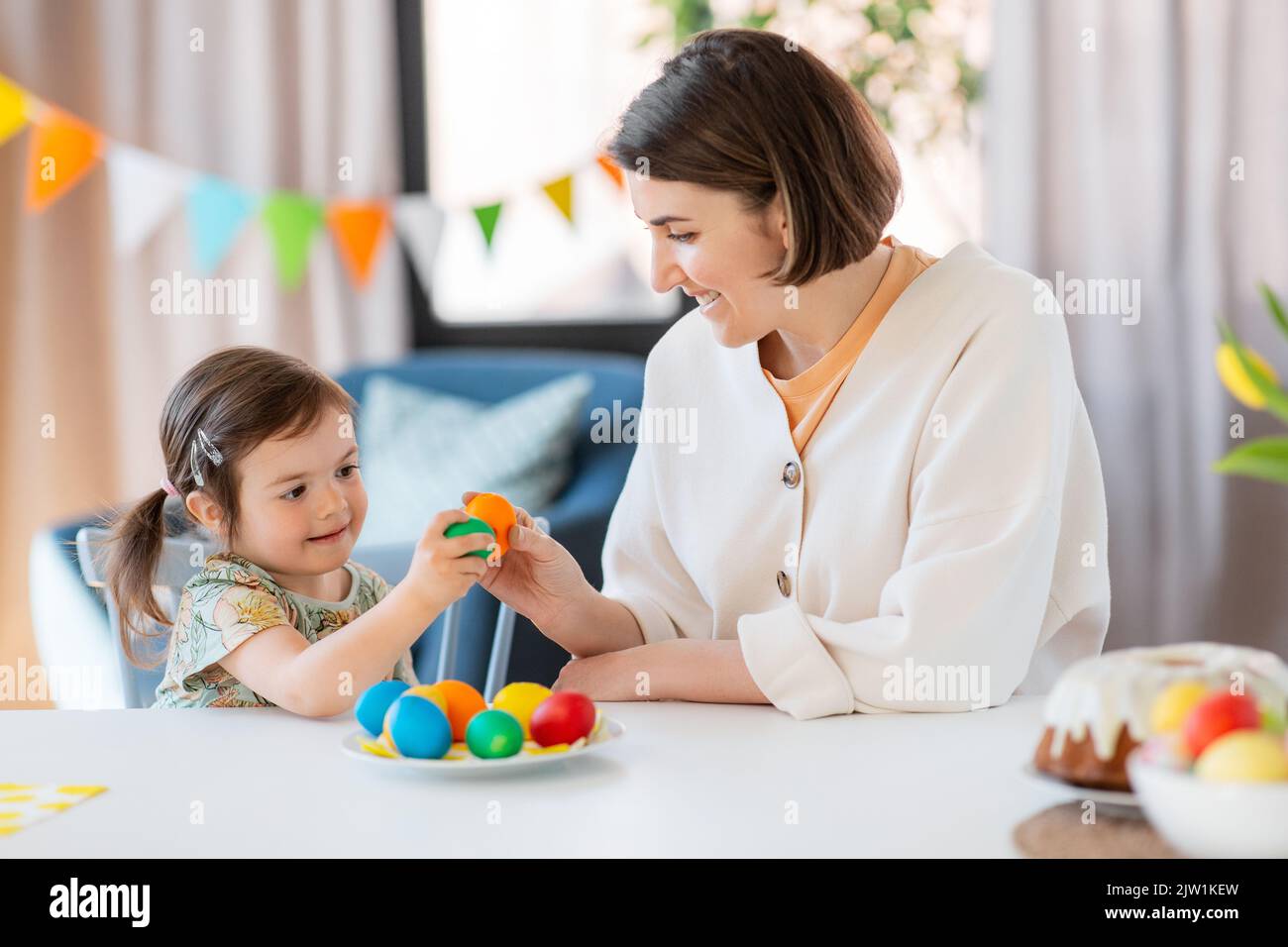 baby girl and mother tapping easter eggs at home Stock Photo - Alamy