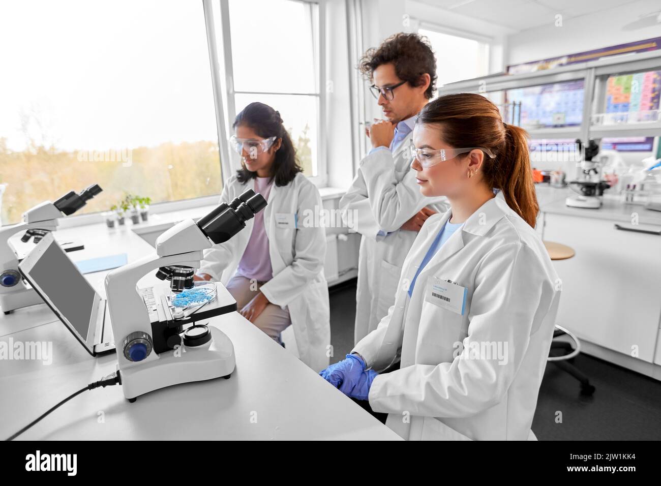 scientists with microscopes working in laboratory Stock Photo - Alamy