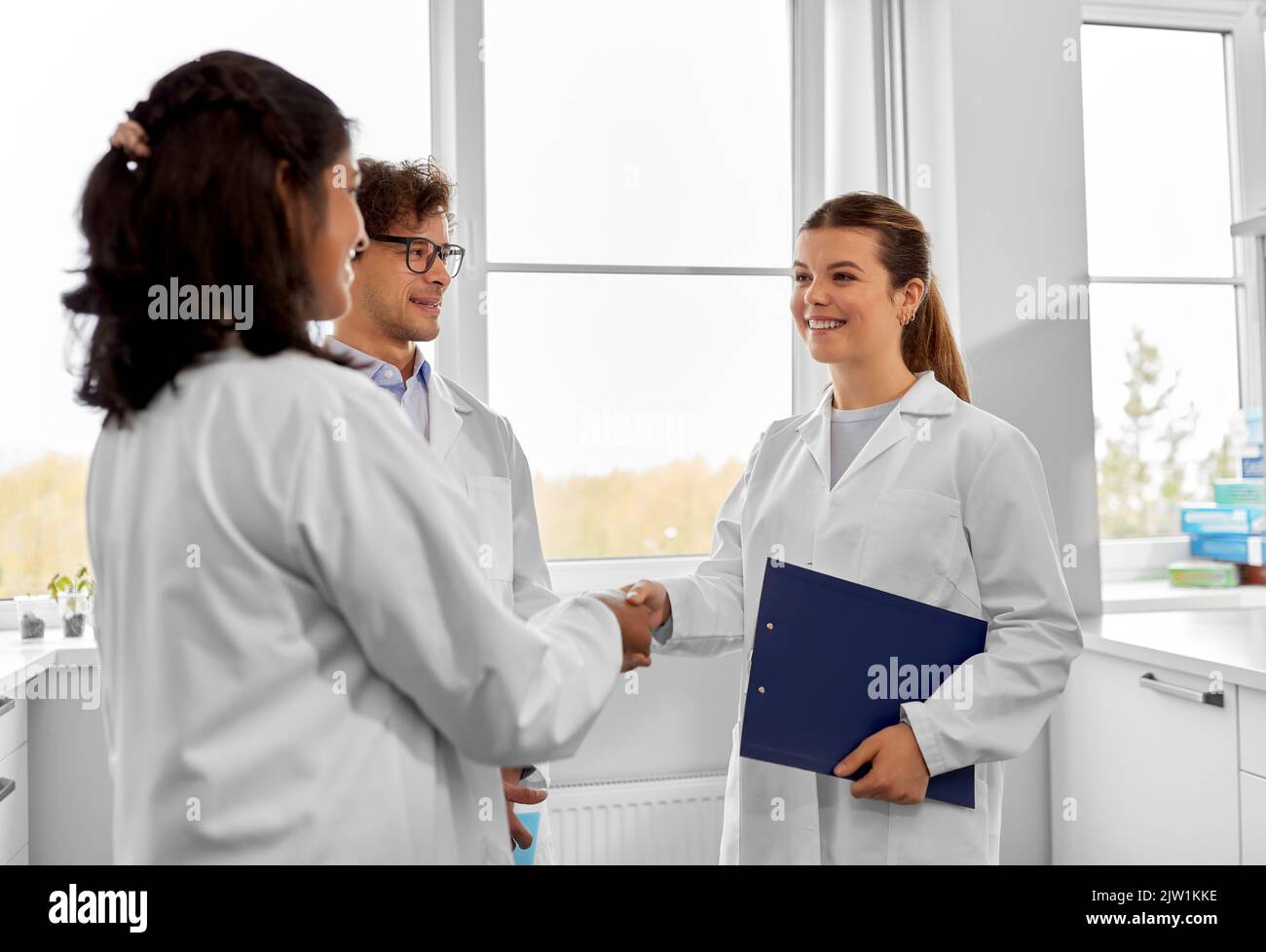 scientists shaking hands in laboratory Stock Photo - Alamy