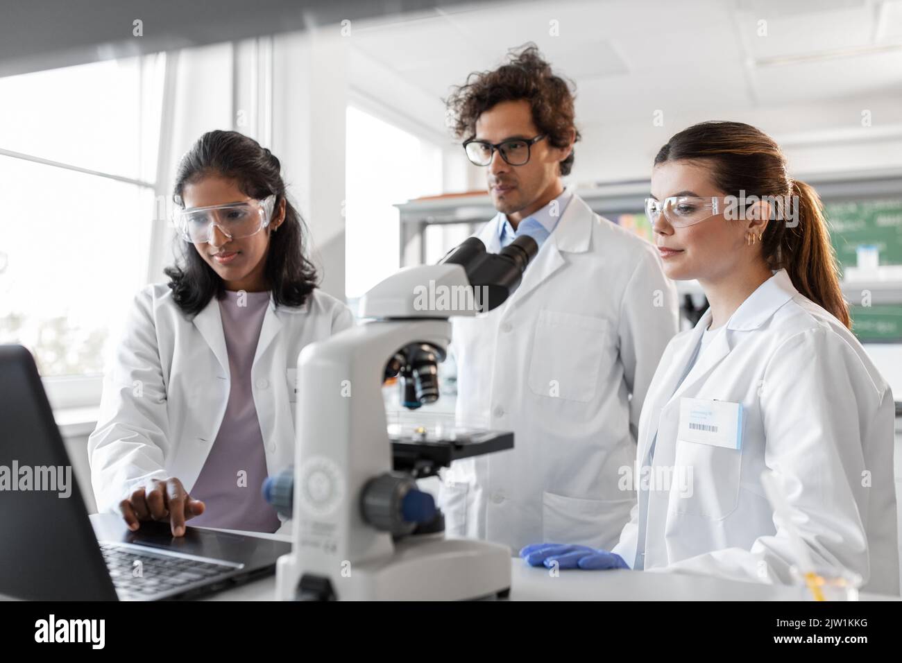 scientists with microscope working in laboratory Stock Photo - Alamy