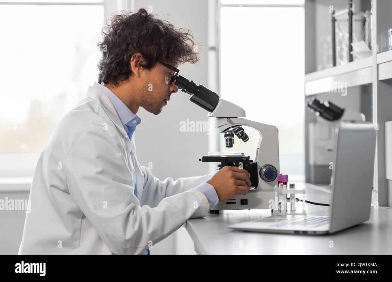 scientist with microscope working in laboratory Stock Photo - Alamy