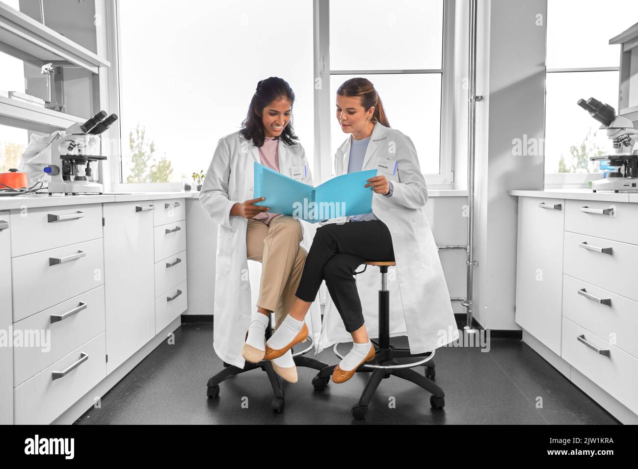 scientists with folder working in laboratory Stock Photo - Alamy