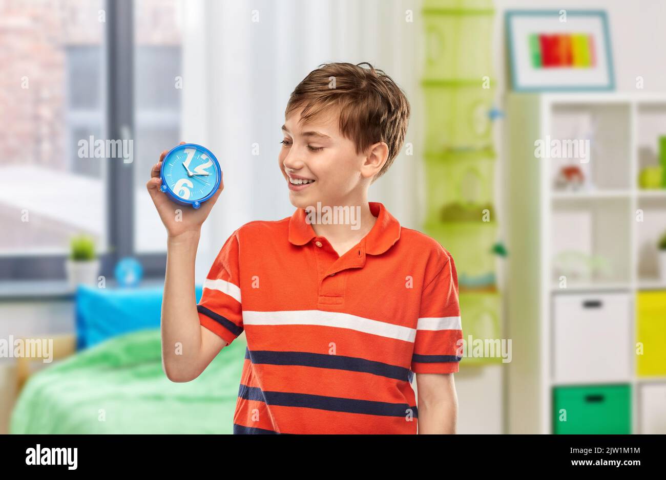 happy smiling boy with alarm clock at home Stock Photo - Alamy