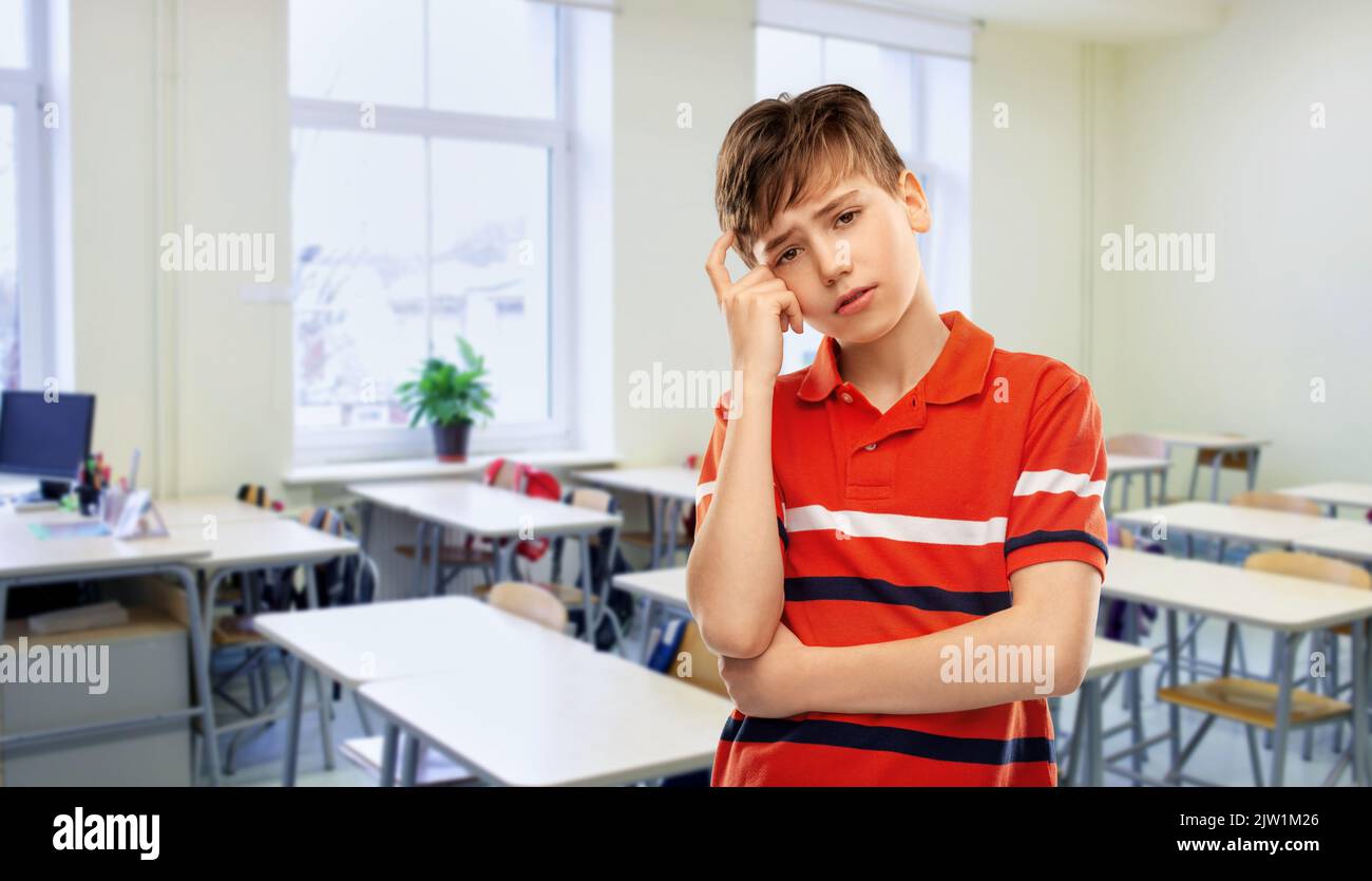 sad thinking boy in red polo t-shirt at school Stock Photo - Alamy