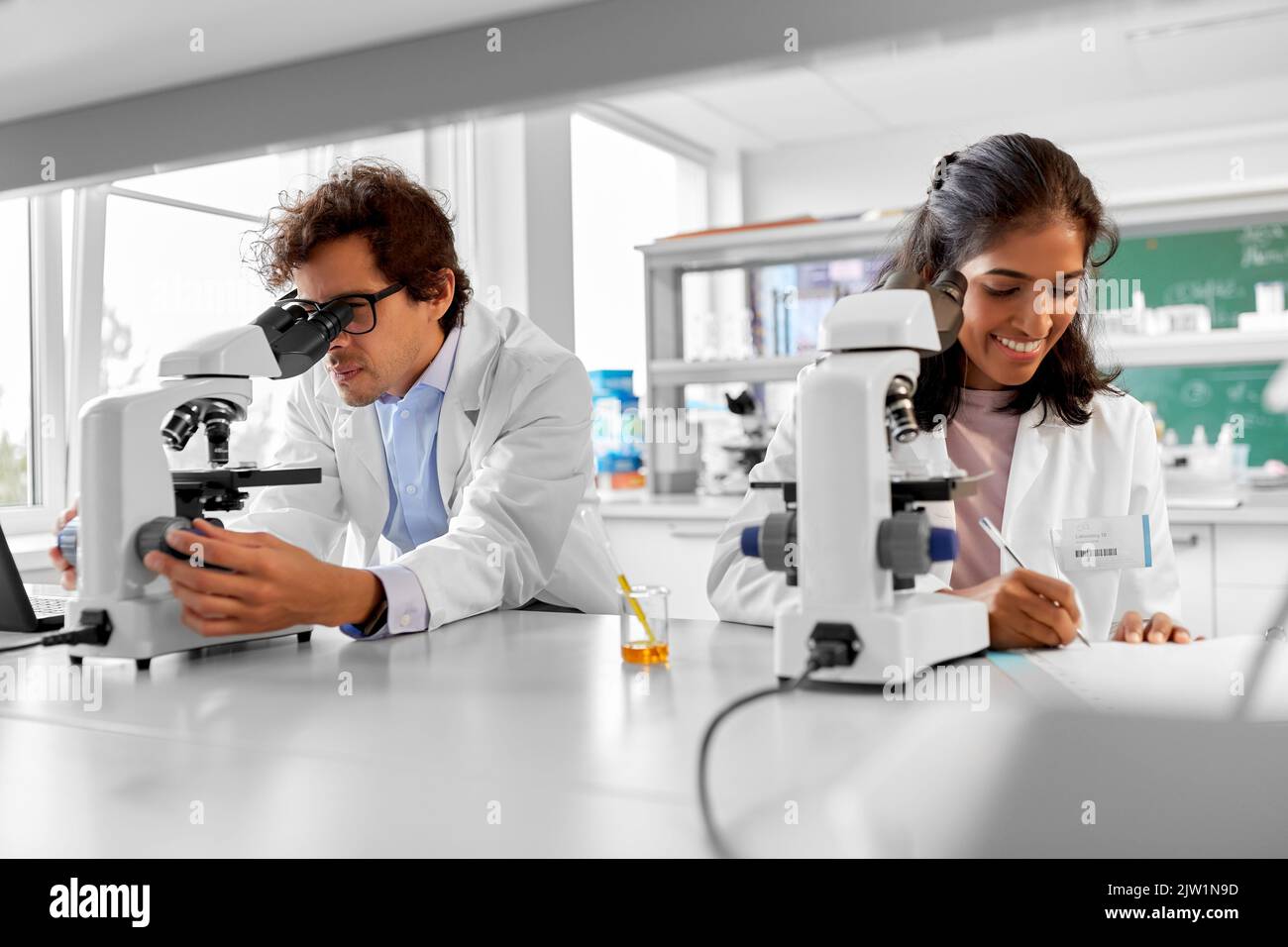 scientists with microscopes working in laboratory Stock Photo - Alamy