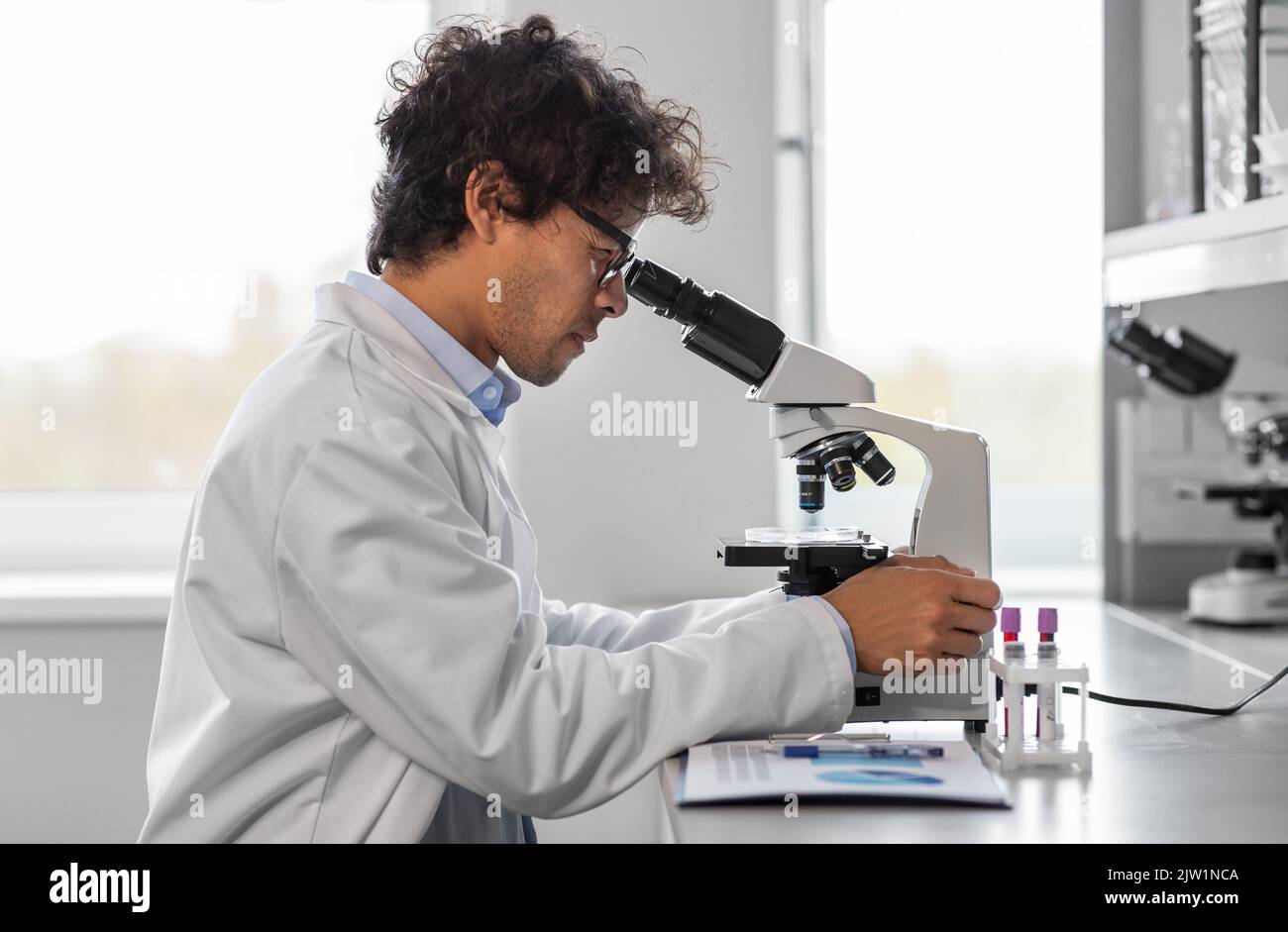 scientist with microscope working in laboratory Stock Photo - Alamy