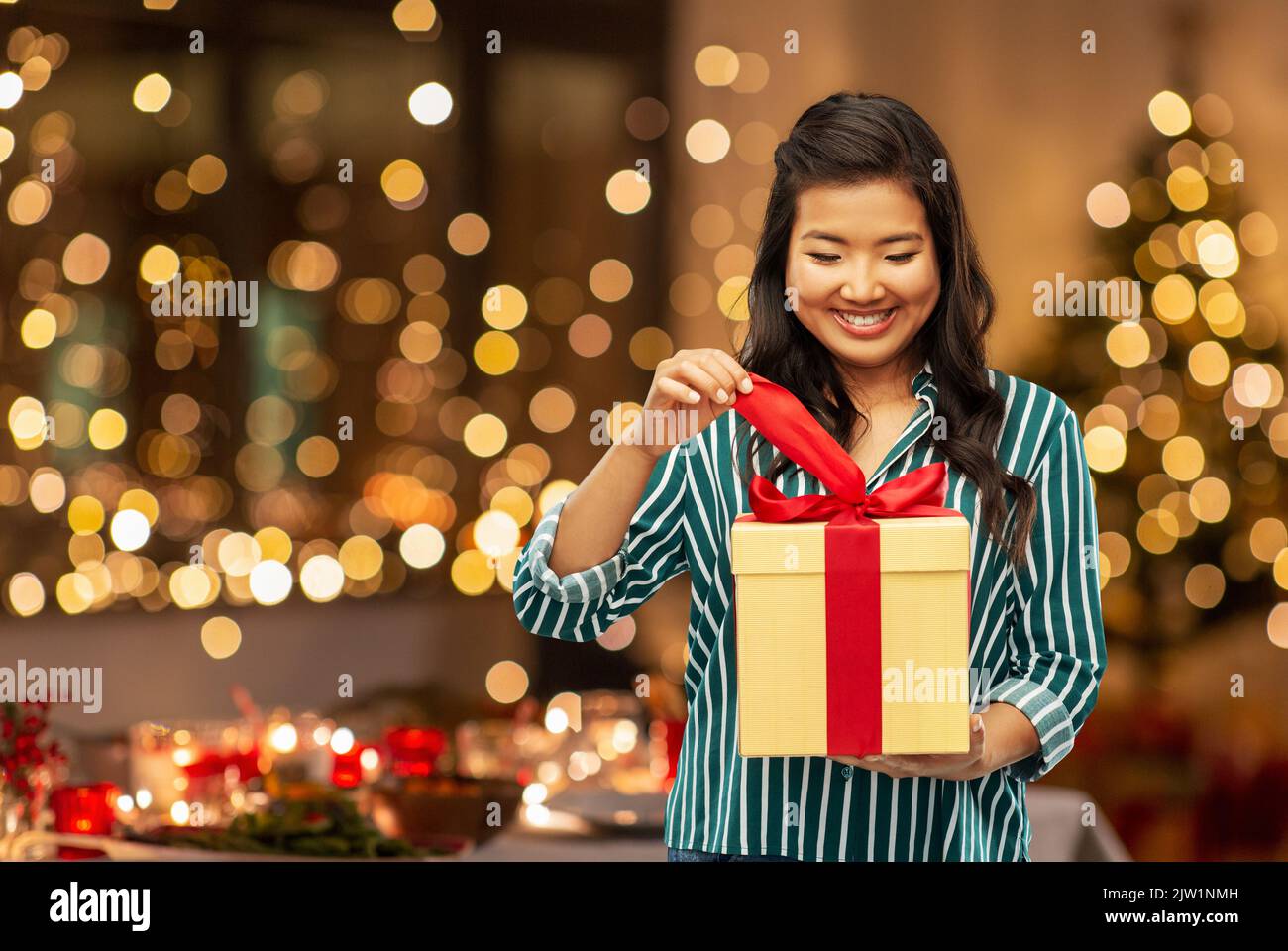 happy woman opening christmas gift Stock Photo - Alamy