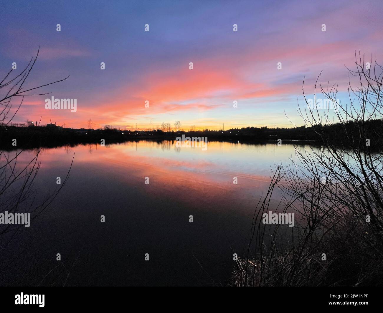 The pastel-colored sunset sky reflected in a lake Stock Photo - Alamy