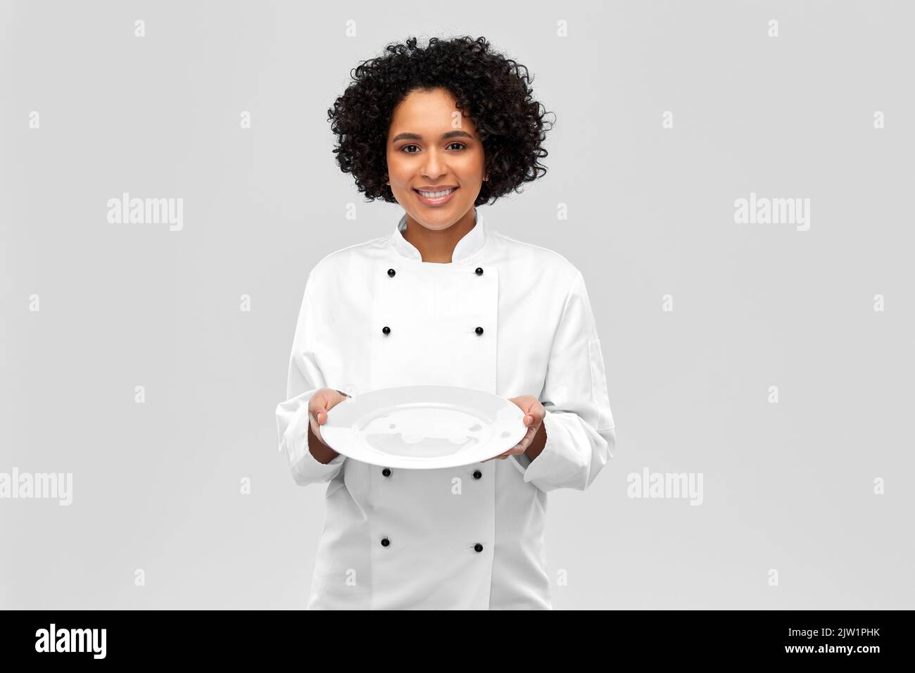 happy smiling female chef holding empty plate Stock Photo - Alamy