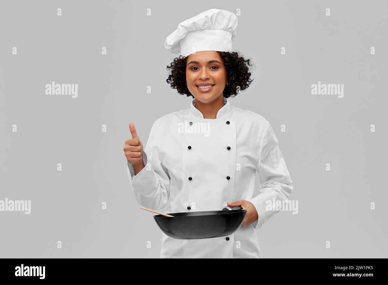 female chef with frying pan showing thumbs up Stock Photo - Alamy