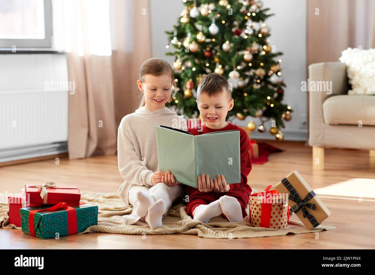 happy children reading book on christmas at home Stock Photo - Alamy