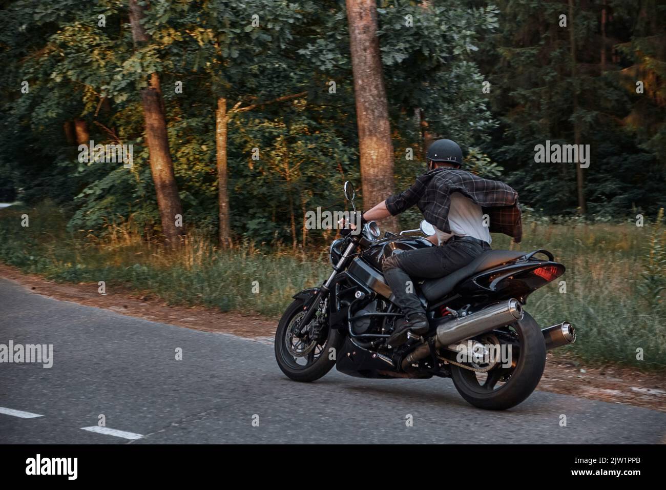 Blurred Motion A young man biker in a helmet quickly rides at high ...