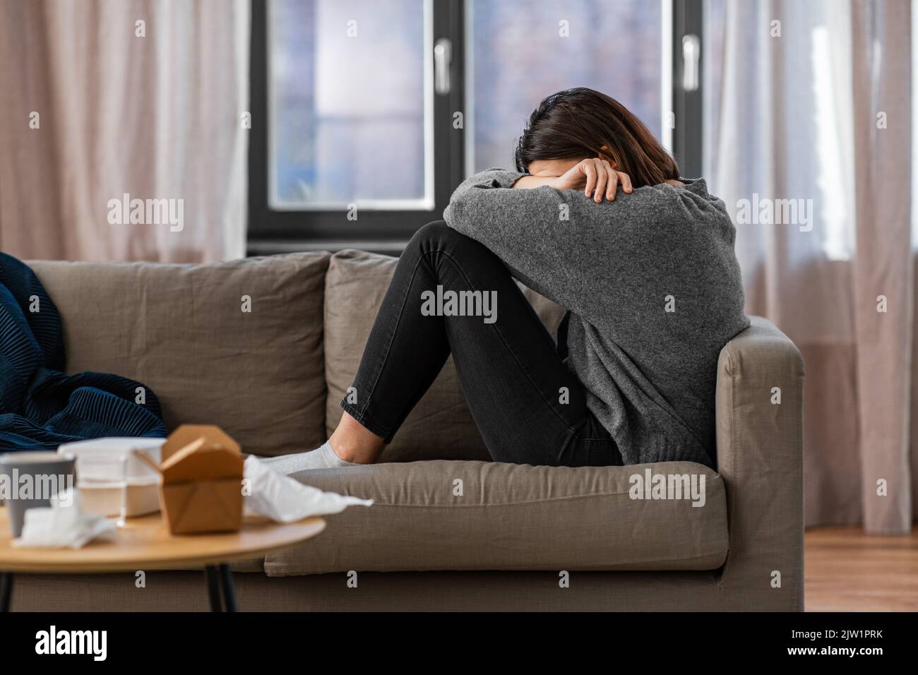 stressed woman sitting on sofa at home Stock Photo - Alamy