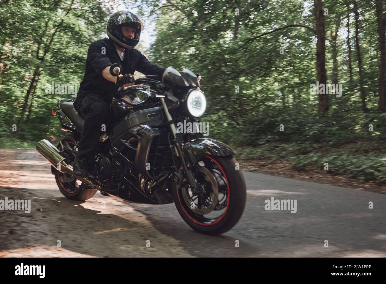 Blurred Motion Young male biker in a helmet travels on a motorcycle ...