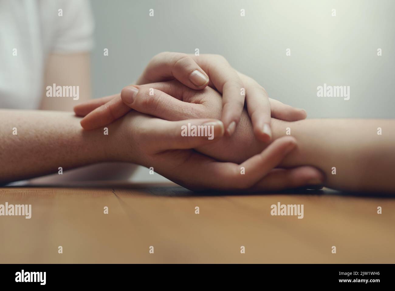 Supporting a dear friend. two people holding hands in comfort Stock ...