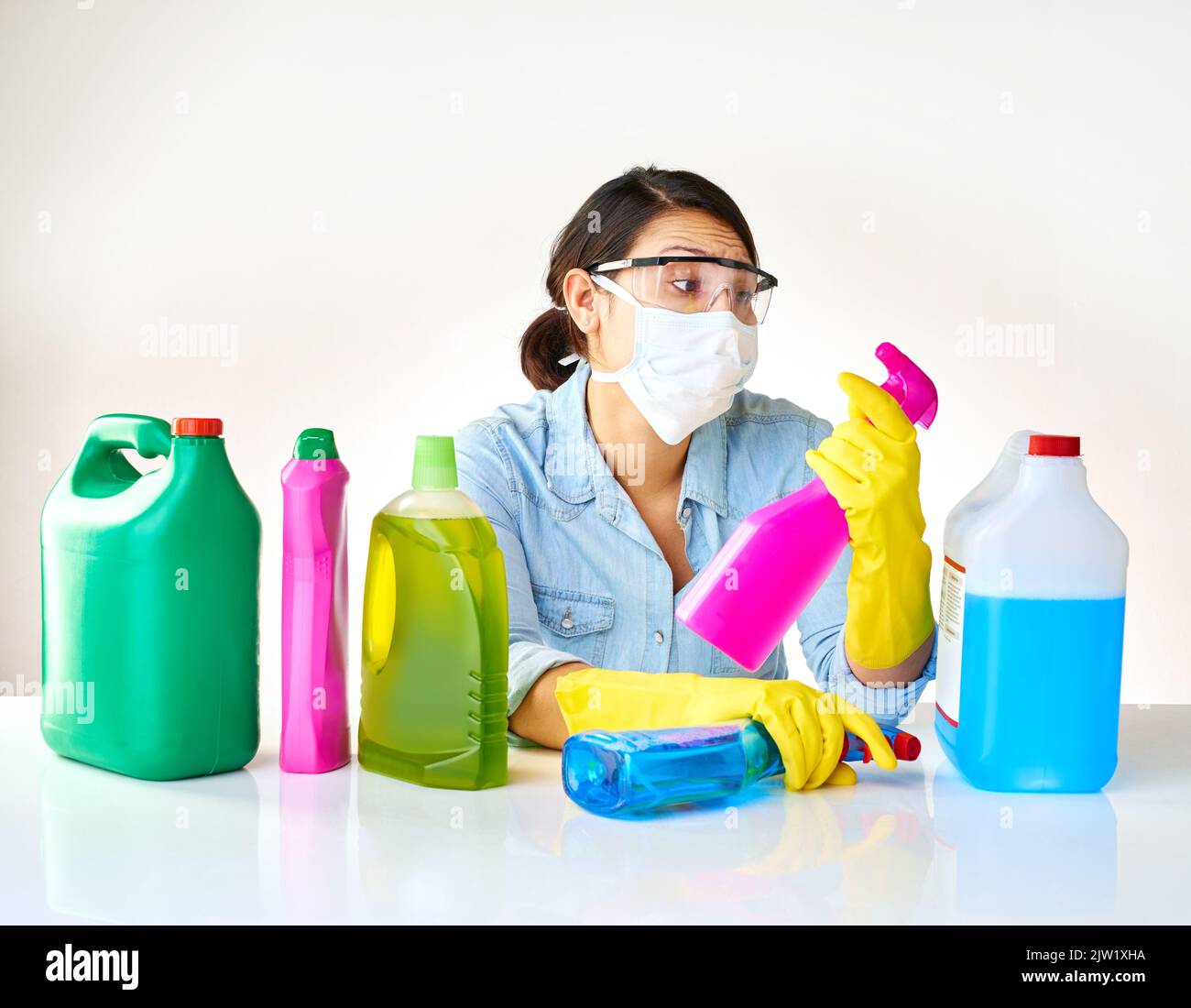 Spoilt for choice on what to use for chores. a young woman holding ...