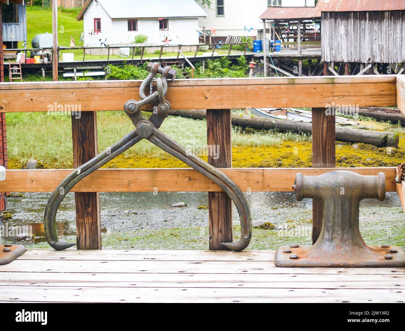 Lifting hook or caliper on shackle over railing and iron bollard on ...