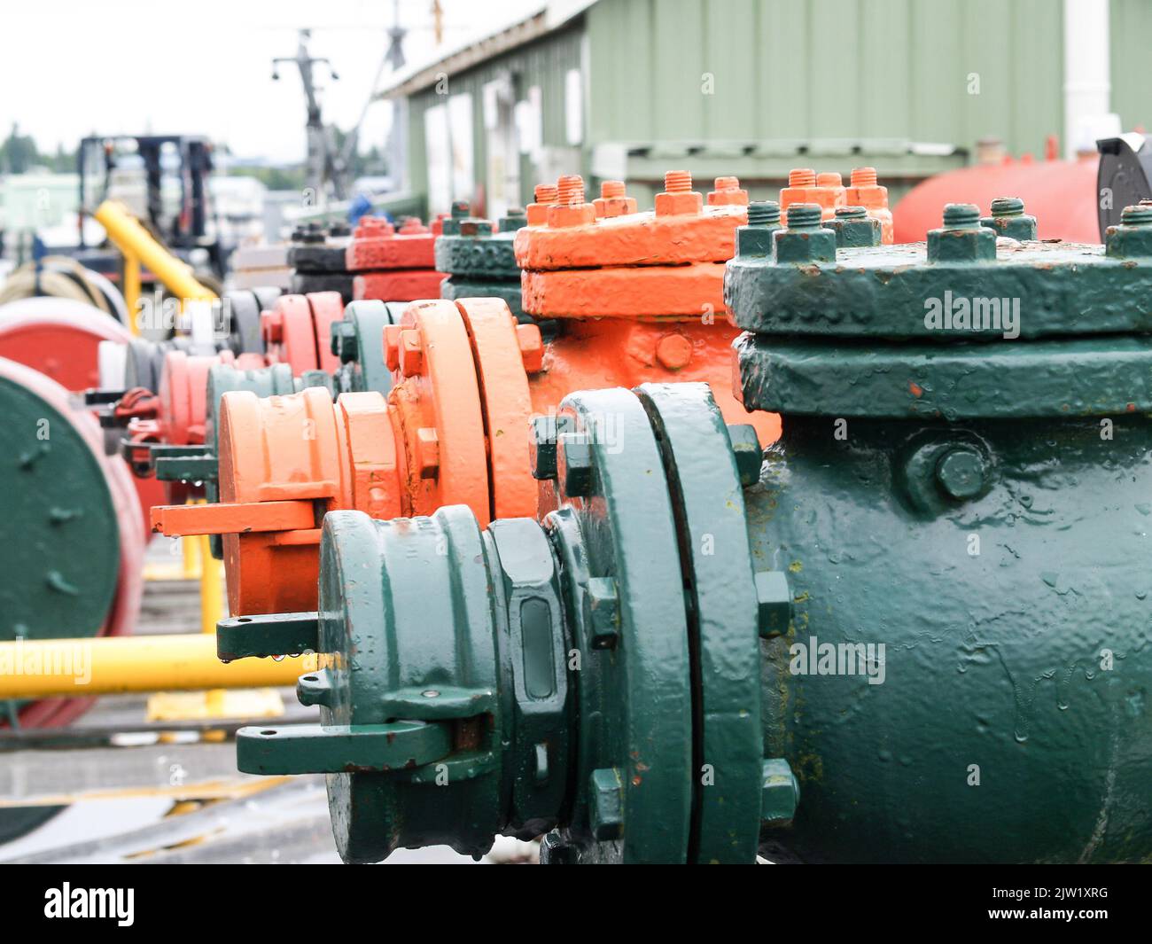 Industrial Flow valves in different colors in line on wharf,close-up ...