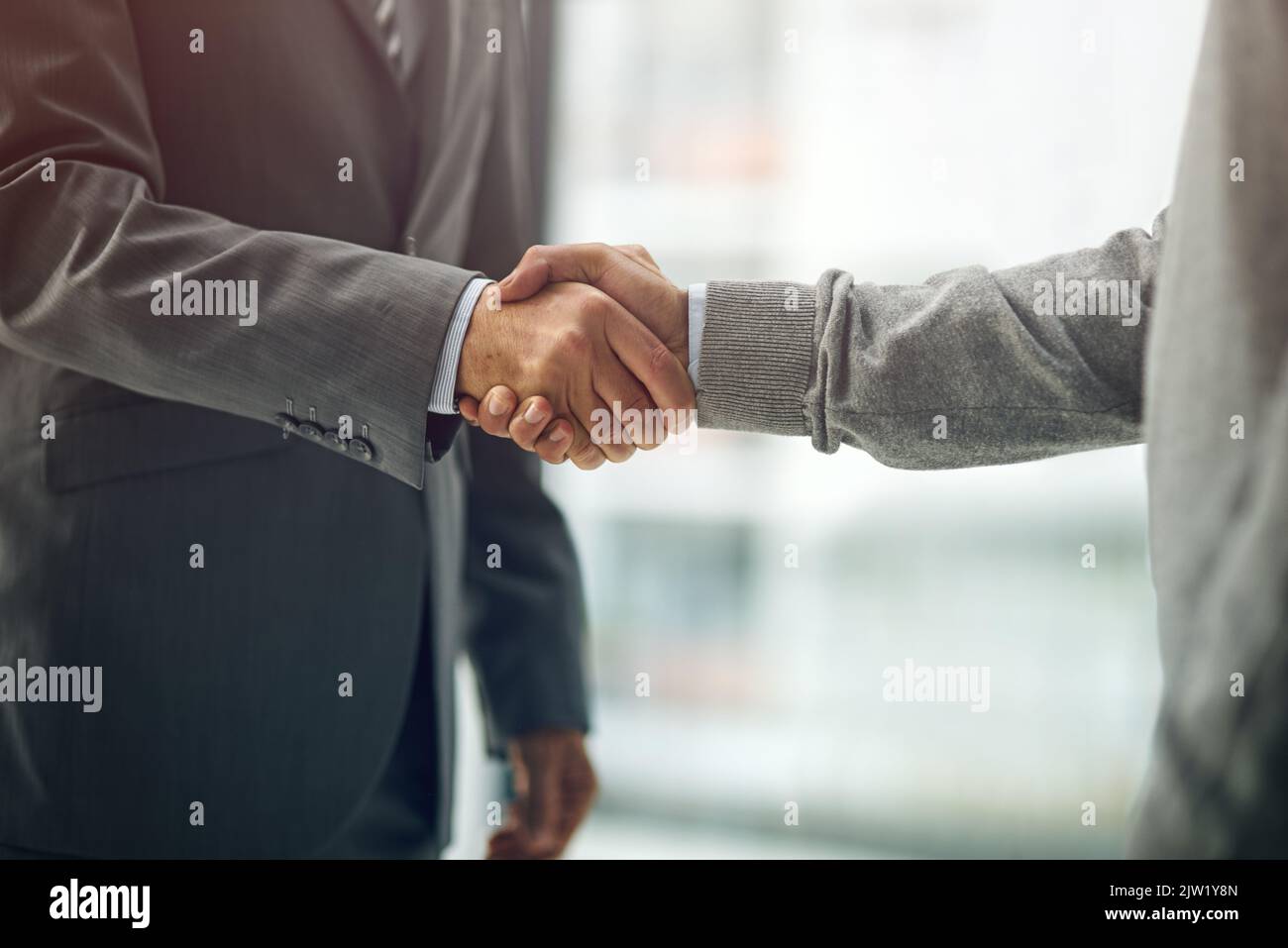We have a deal. two unrecognizable businessmen shaking hands in an ...