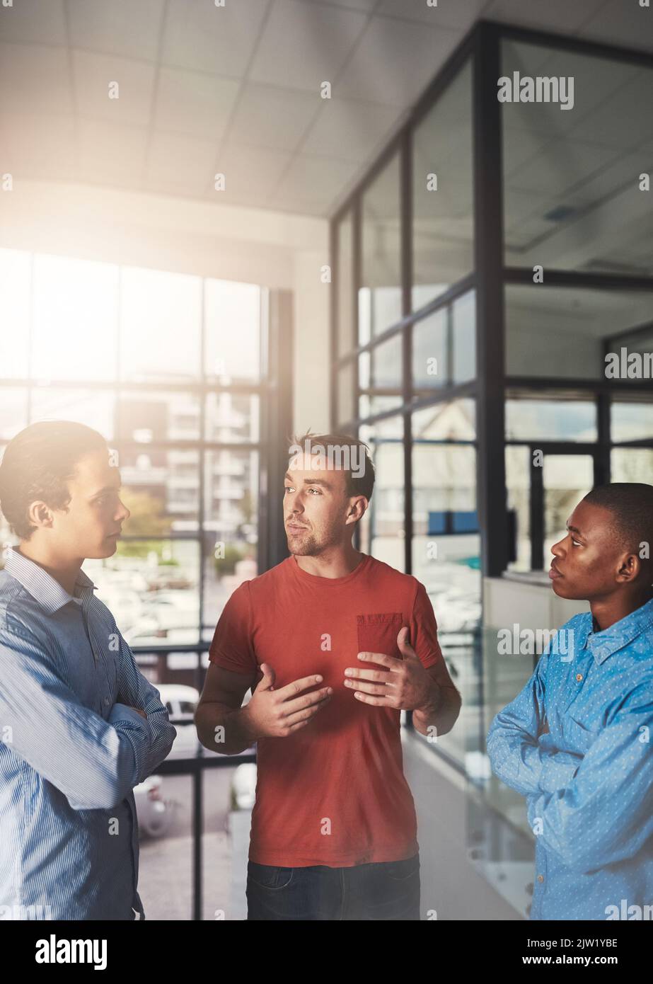 Sharing innovative ideas. three colleagues having a discussion in an ...