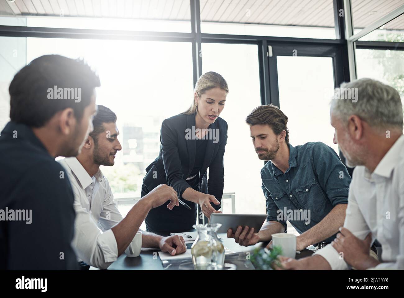 Getting down to business. a businesswoman talking to colleagues sitting ...