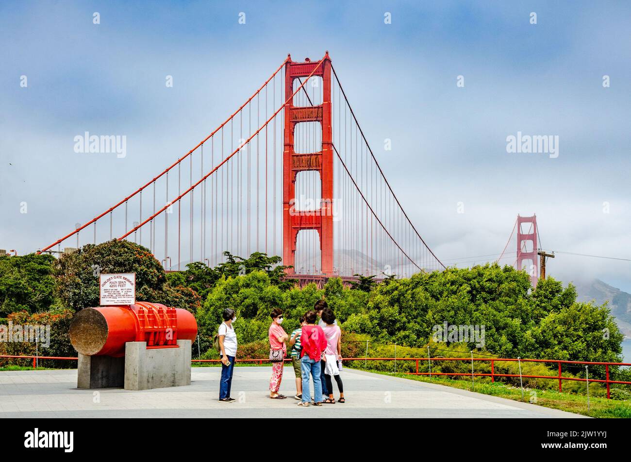 Tourists stand by a cross section of one of the cables which makes up ...