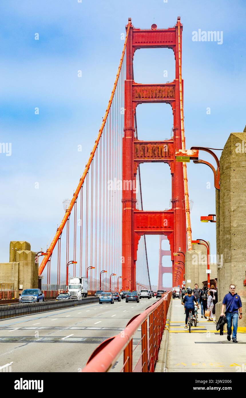 People walking and cars driving across The Golden Gate Bridge in San ...