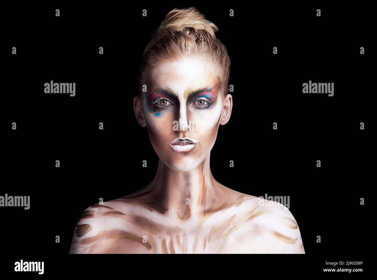 Strange and surreal. Studio portrait of a young woman posing with paint ...