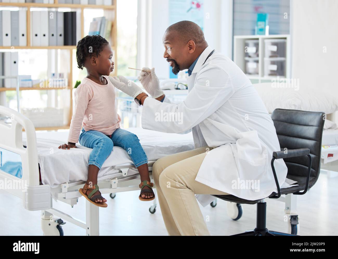 Doctor, mouth of child and black man helping little girl in checkup or ...