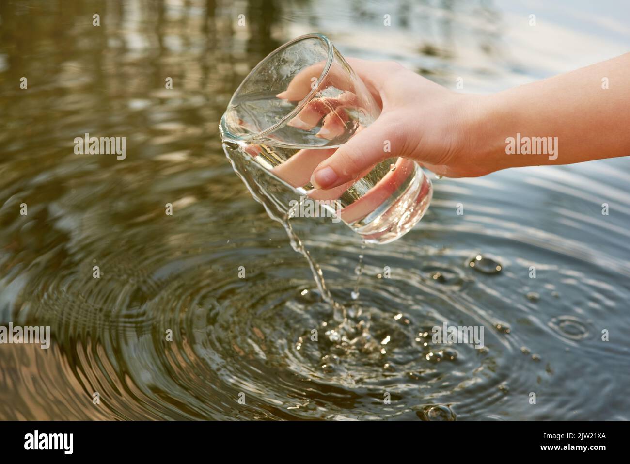 Be water wise. water being poured out from a glass into a pond Stock ...