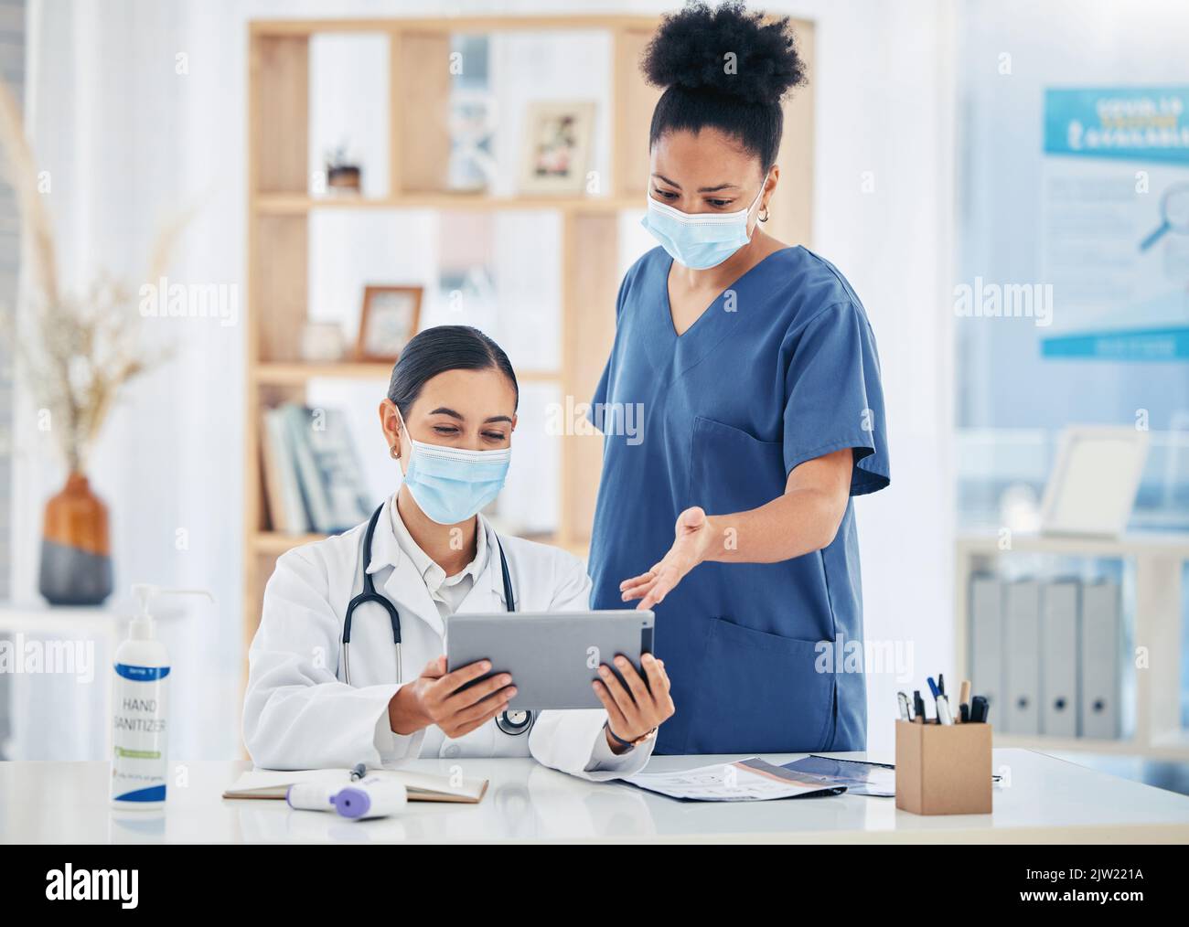 Covid, mask and tablet with a doctor and nurse in the hospital doing ...