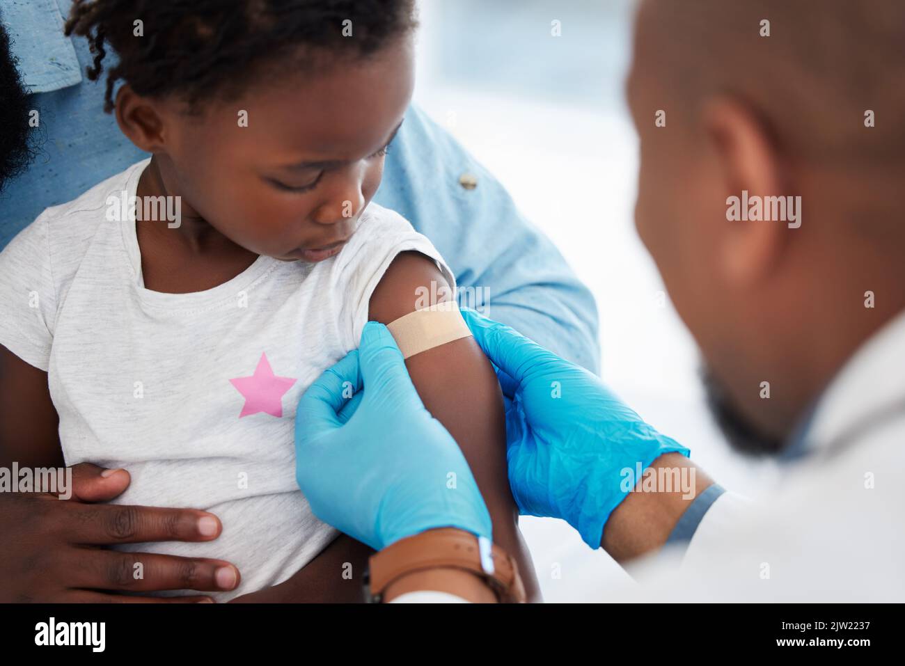 Child, healthcare vaccine and doctor with plaster for skin protection ...