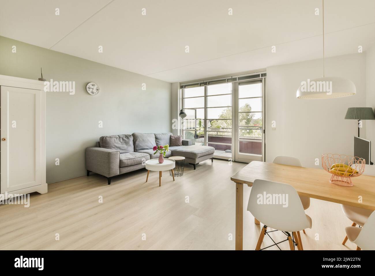 Table with chairs and flowers located near lounge area and kitchen in ...