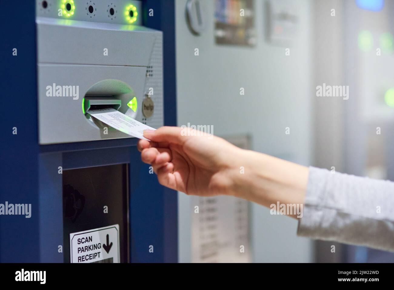 Secure parking has its price. an unrecognizable person inserting a ...