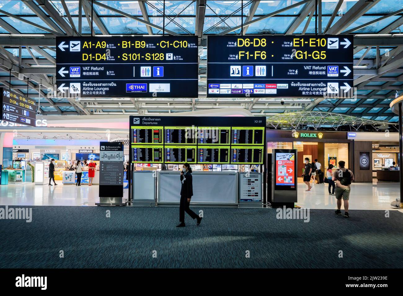 People walk past a large display of departure times inside the Duty ...