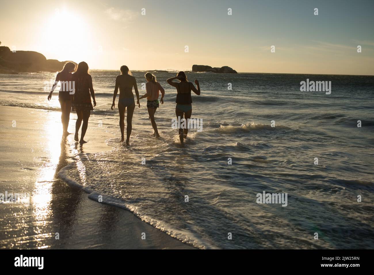 Women walking on the beach at the sunset Stock Photo - Alamy