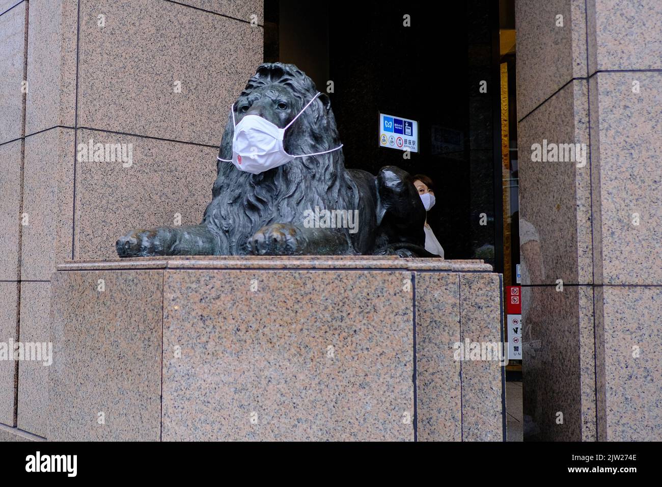 Tokyo, Japan. 24th Aug, 2022. A lion statue wearing a face mask is seen ...