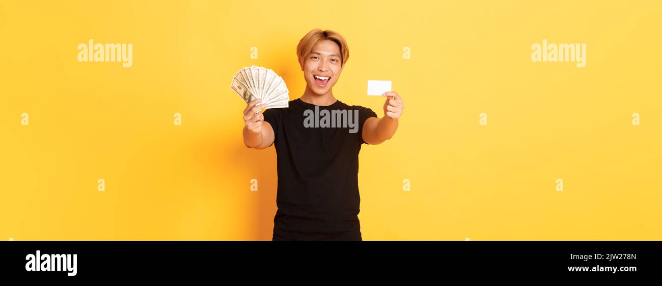 Happy good-looking asian guy in black casual clothes, showing money and ...